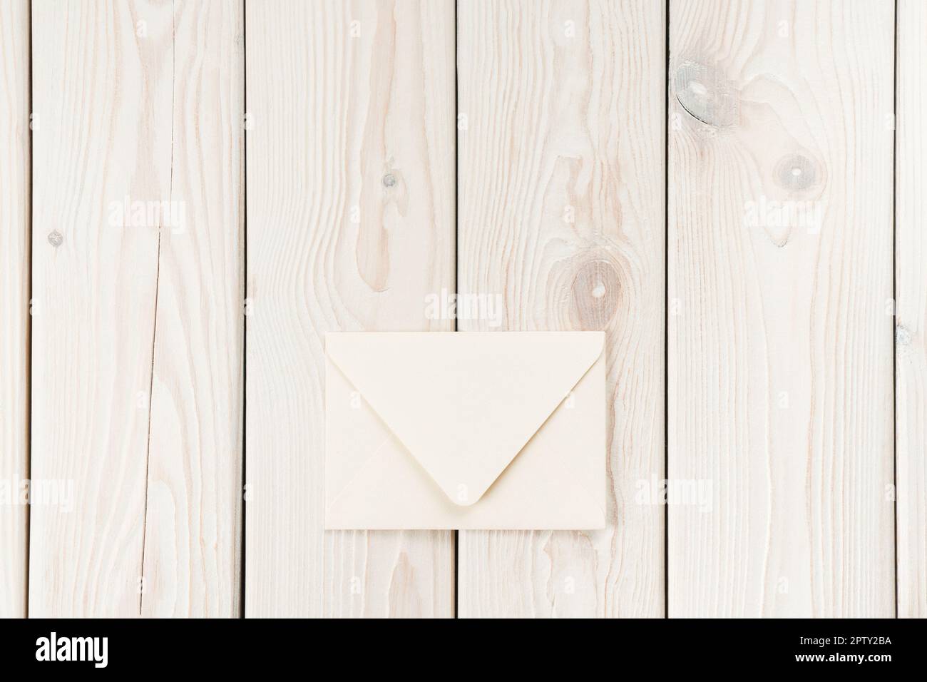 White craft handmade closed paper envelope laying on white wooden plank ...