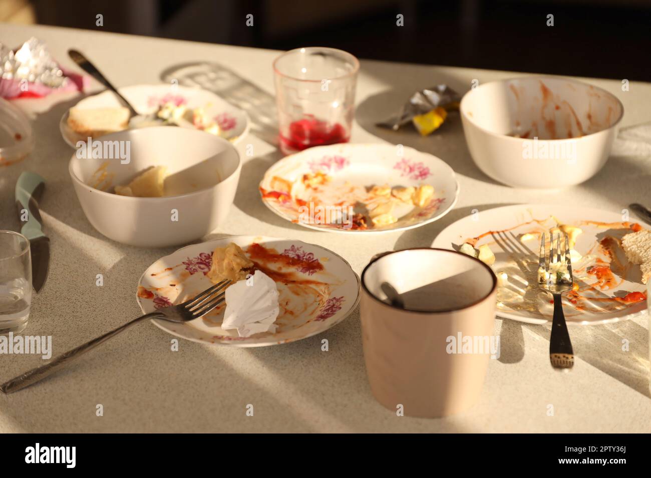 Empty dirty plates with spoons and forks on the table after meal ...