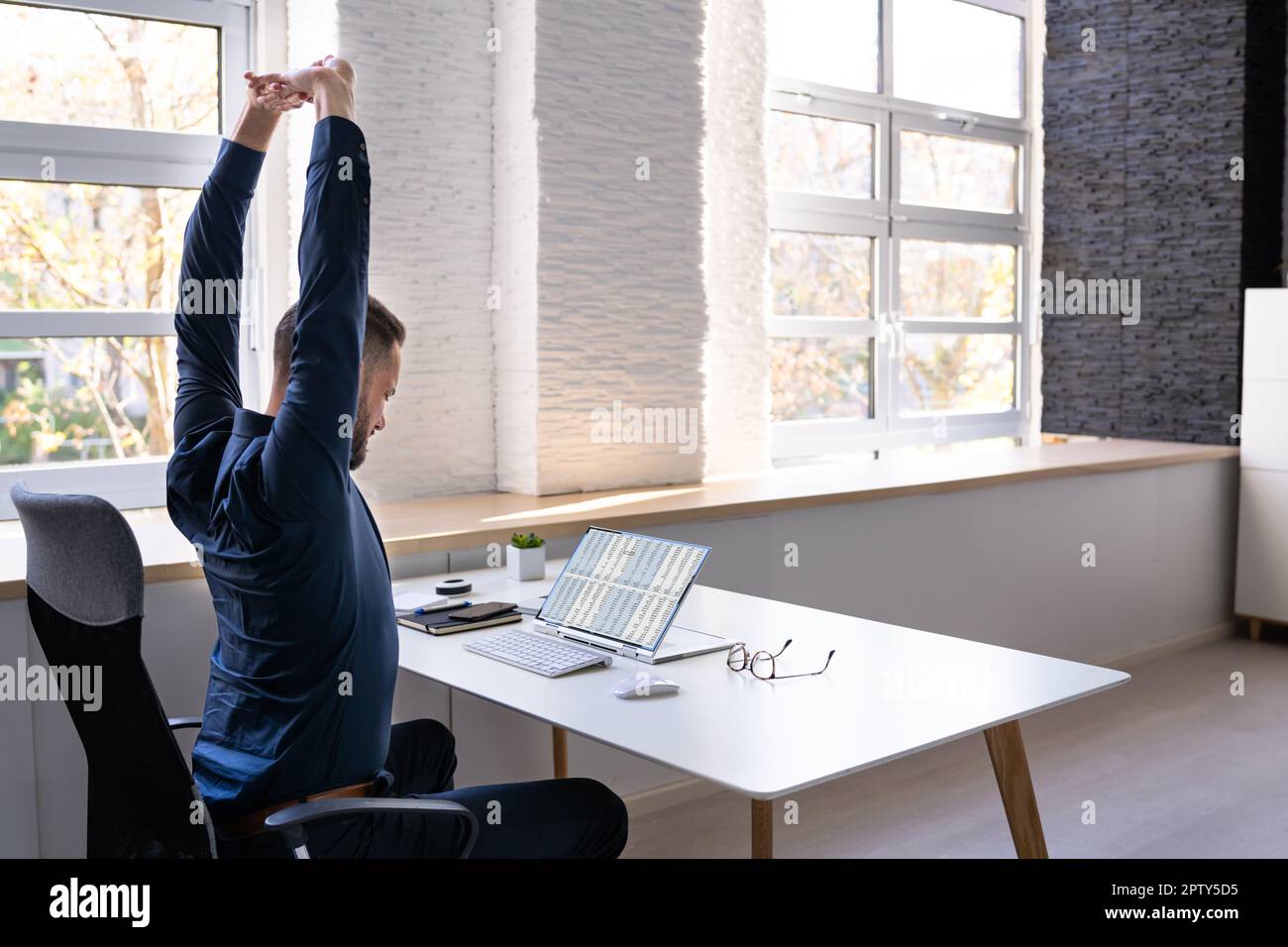 Employee Stretching At Office Desk At Work Stock Photo - Alamy
