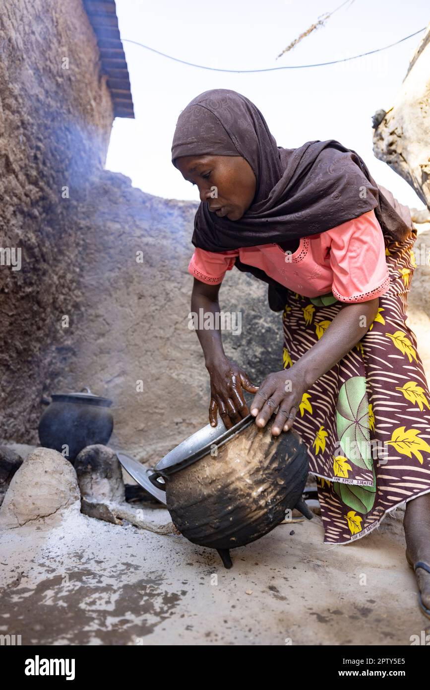 African woman cooking with a pot over an open fire in Segou Region ...