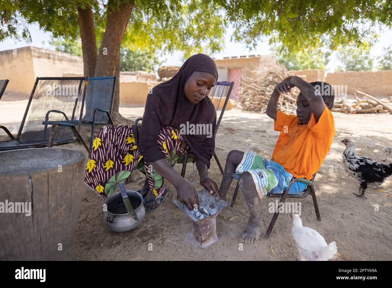 A mother cooks over a small charcoal stove in Segou Region, Mali, West ...
