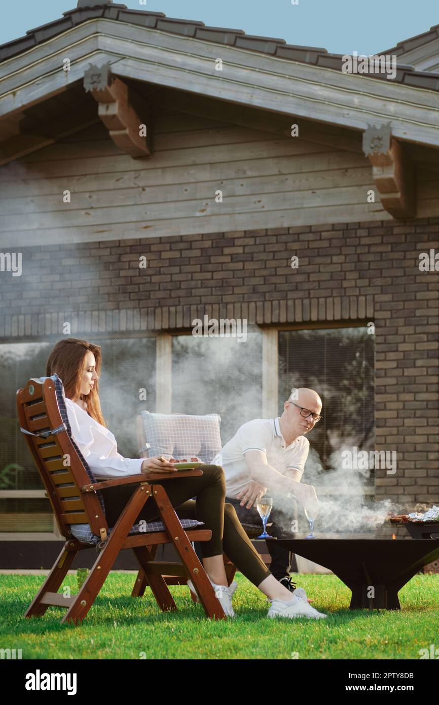 Man woman barbecuing sausages hi-res stock photography and images - Alamy