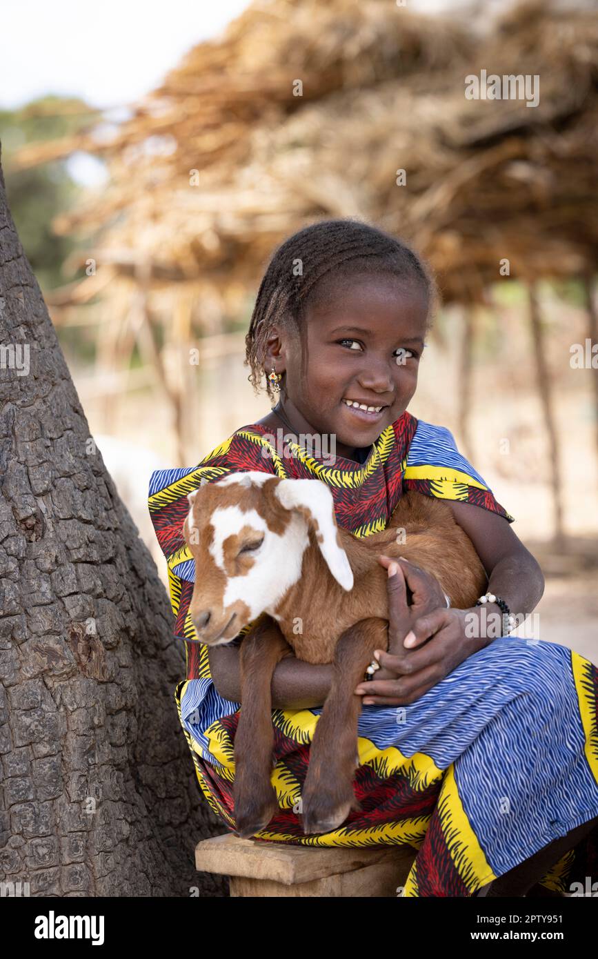 Child holding a goat in her arms in Segou Region, Mali, West Africa ...