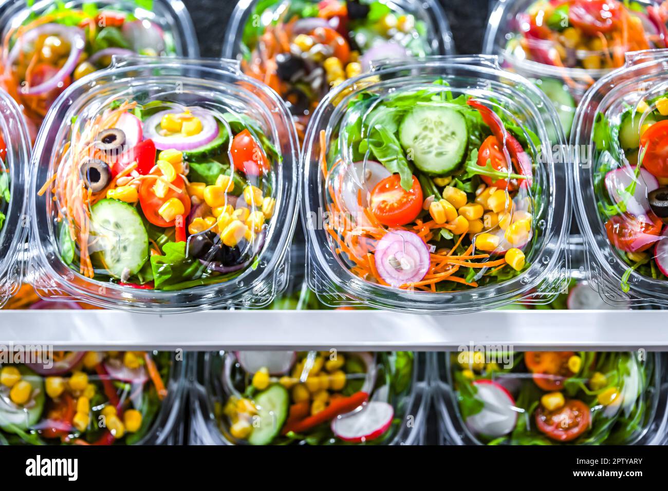 Plastic boxes with pre-packaged vegetable salads, put up for sale in a ...