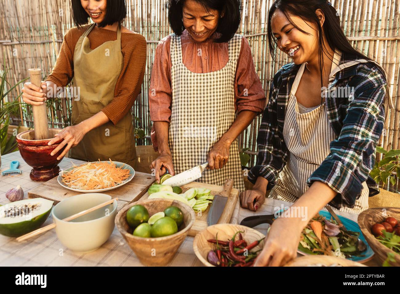 Happy Southeast Asian family having fun preparing Thai food recipe ...