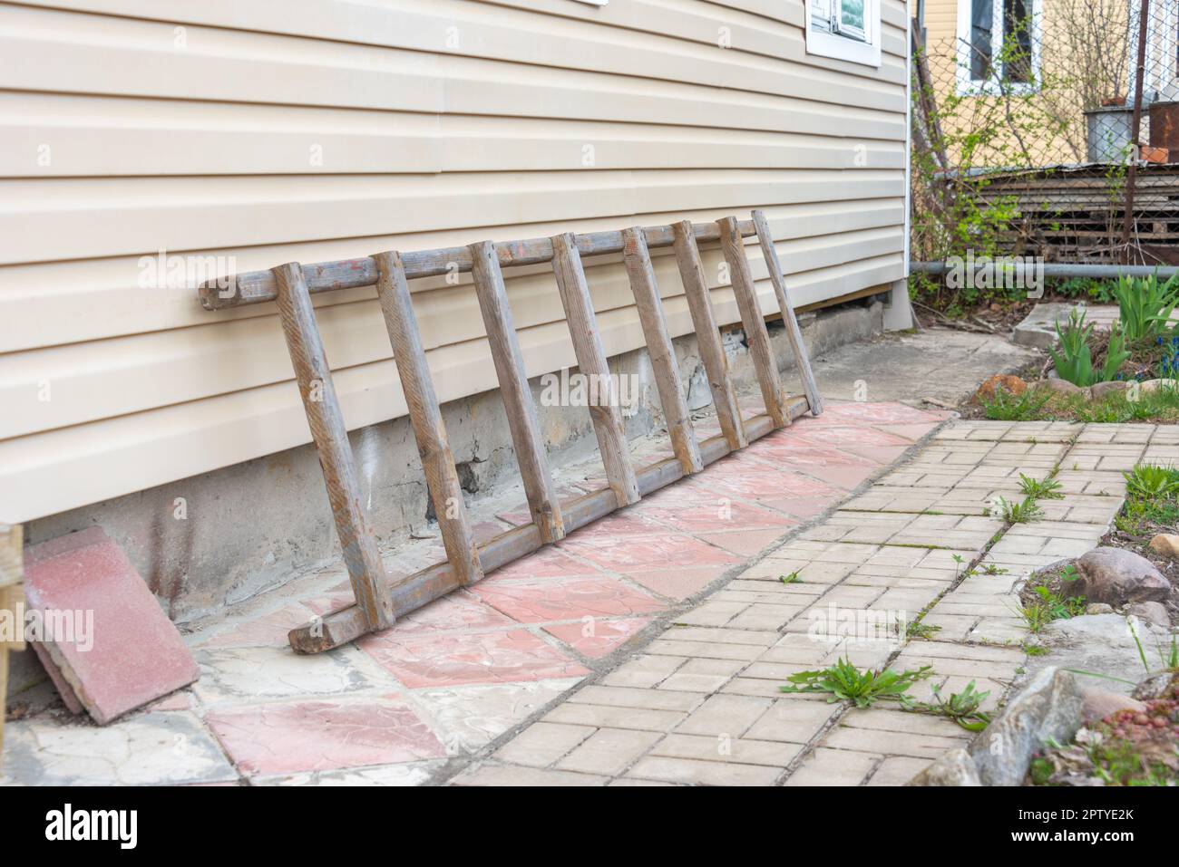 A wooden staircase lies along the facade of a rural house. Village ...