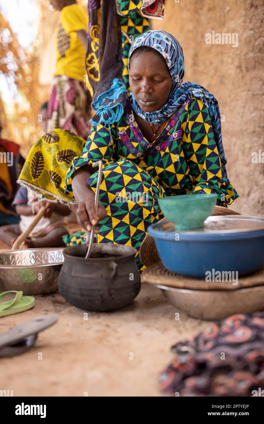 IDP woman serving a meal from her makeshift hut in Segou Region, Mali ...