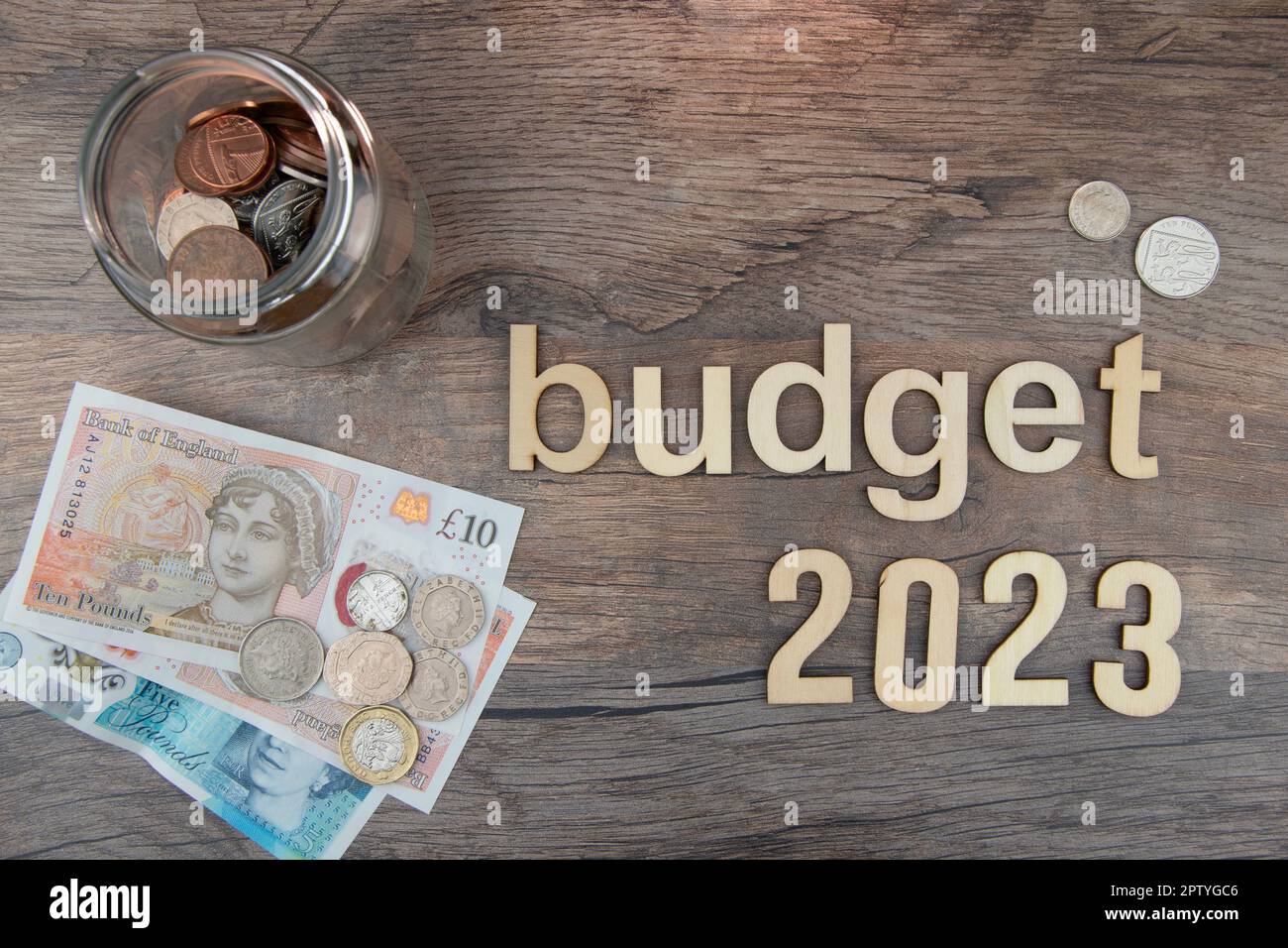 Rustic wood board, bottle of coins, british money Stock Photo - Alamy