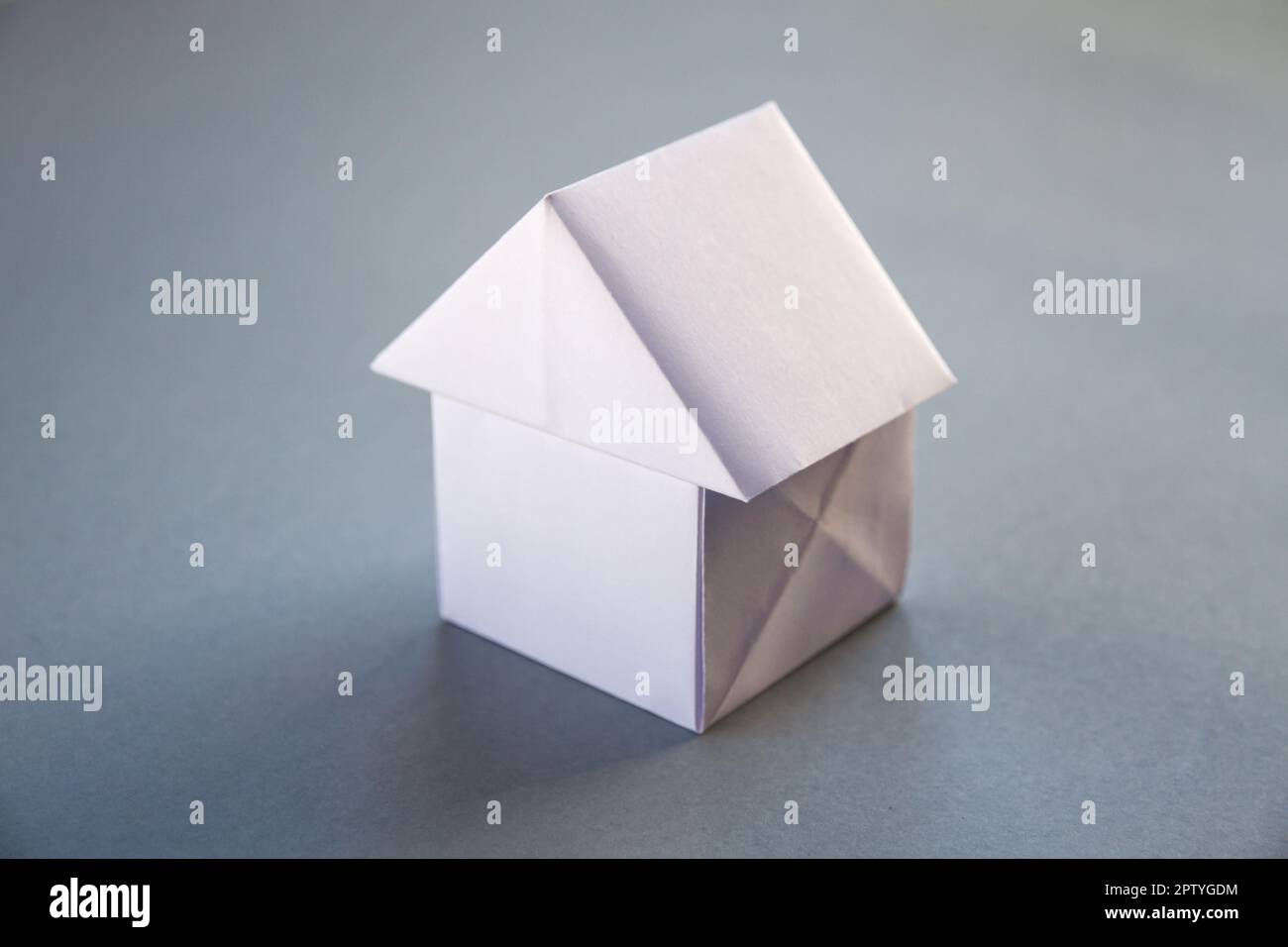 White paper house origami isolated on a blank grey background Stock ...