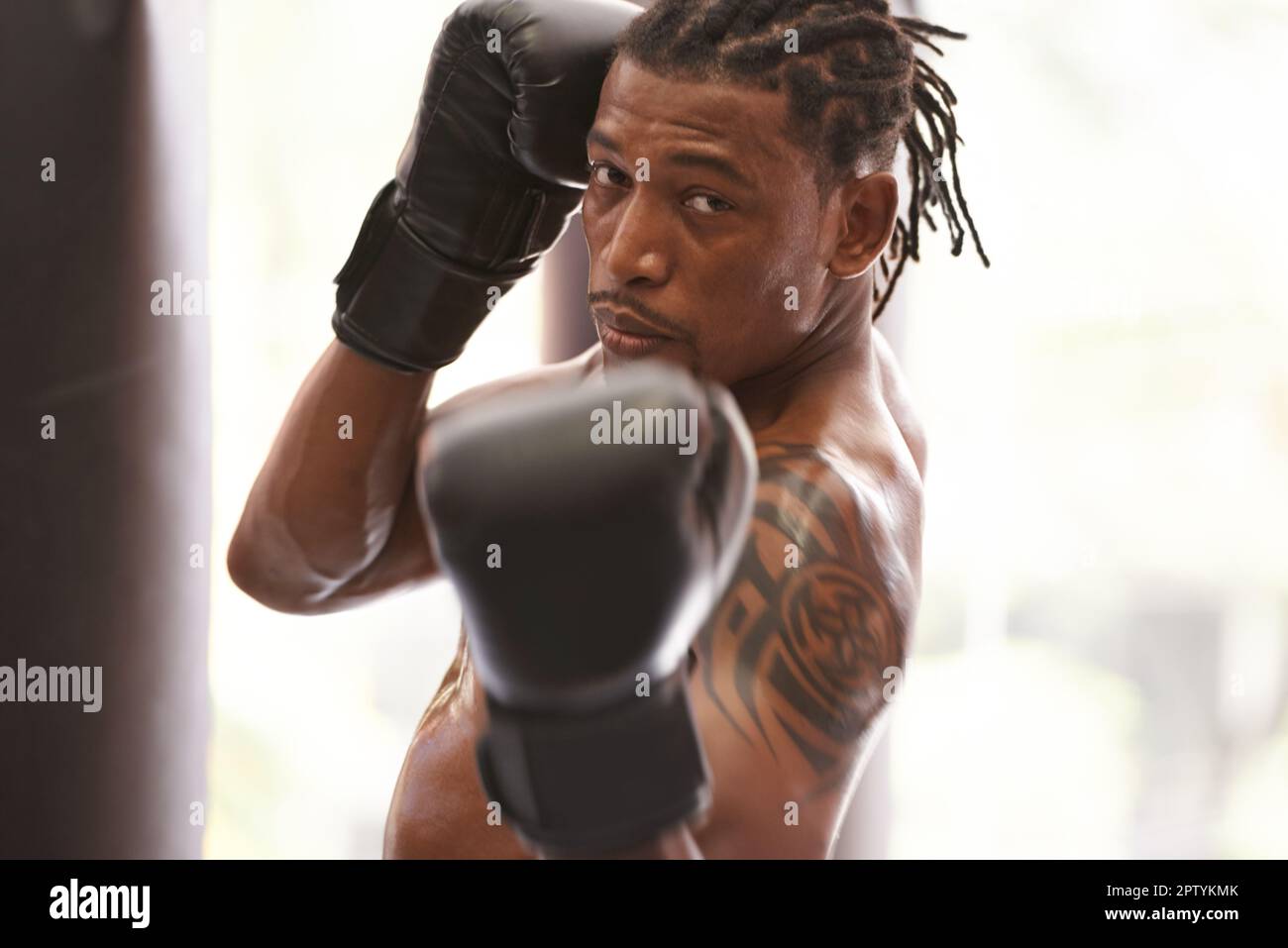 One mean upper cut. Portrait of a young boxer practicing in a gym Stock ...