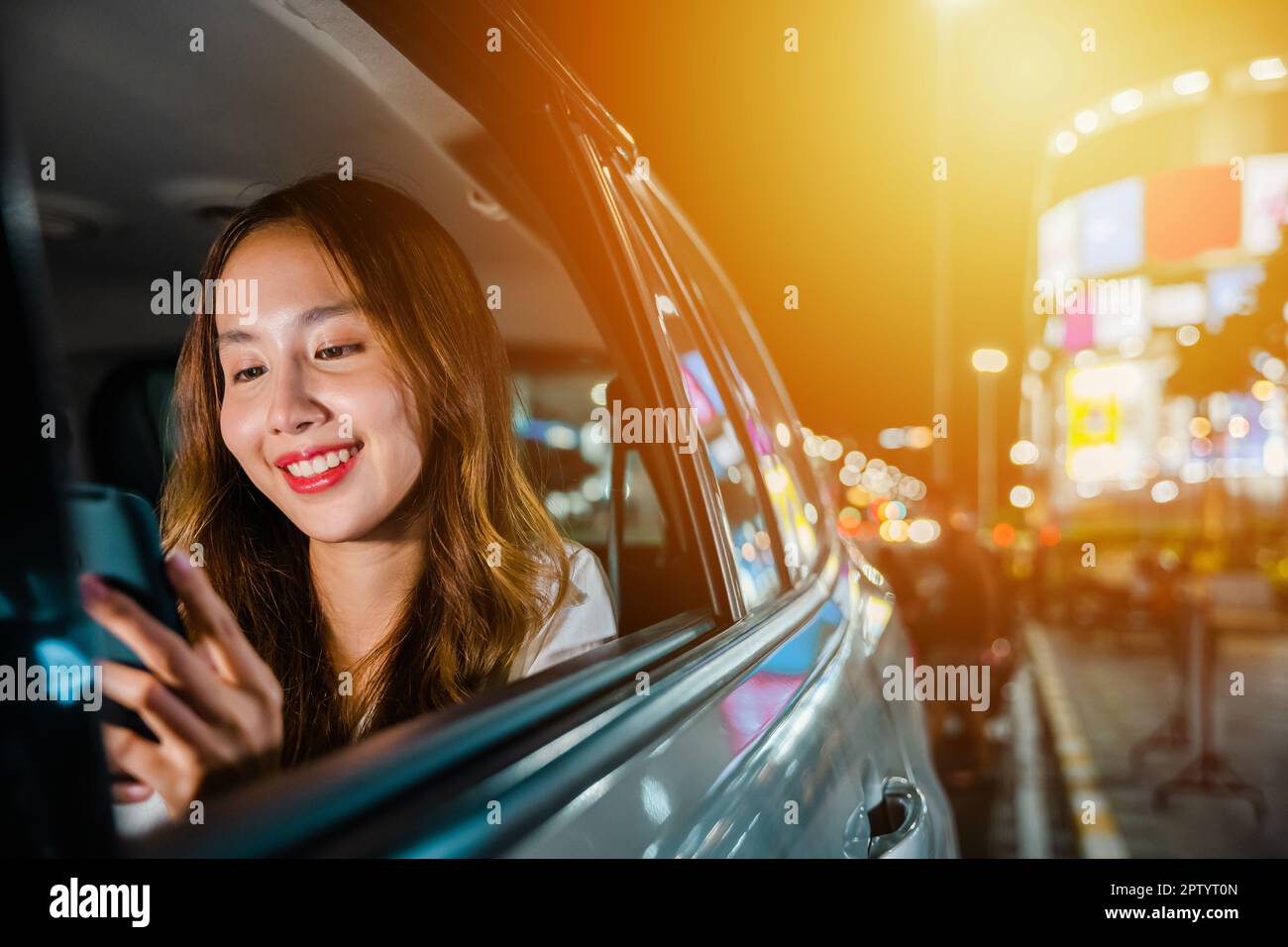 Asian businesswoman working late commuting from office in Taxi backseat ...
