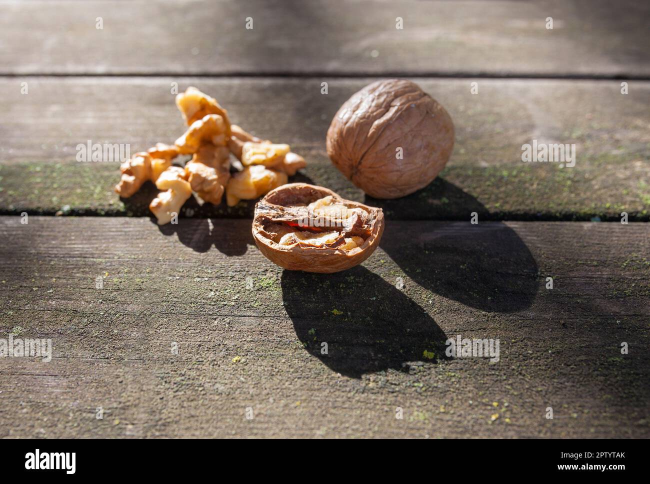 Walnuts over wooden picnic table. Natural light shot Stock Photo - Alamy
