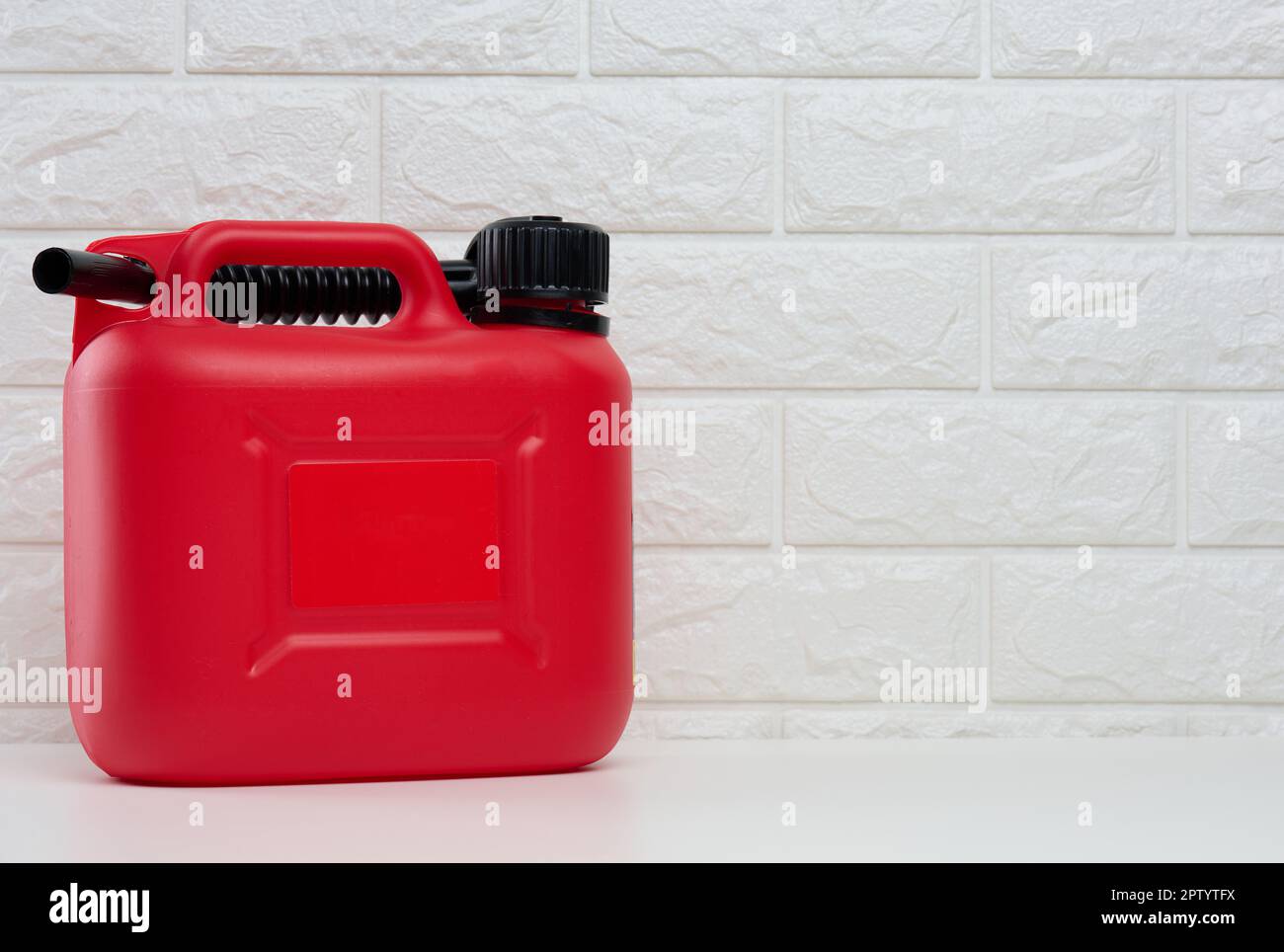 Red plastic canister for liquid fuels and lubricants on a white ...