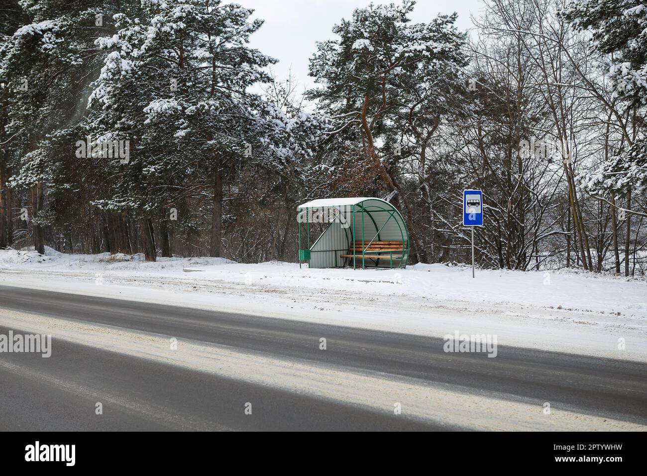 Bus stop in the middle of a beautiful winter road in the middle of the ...