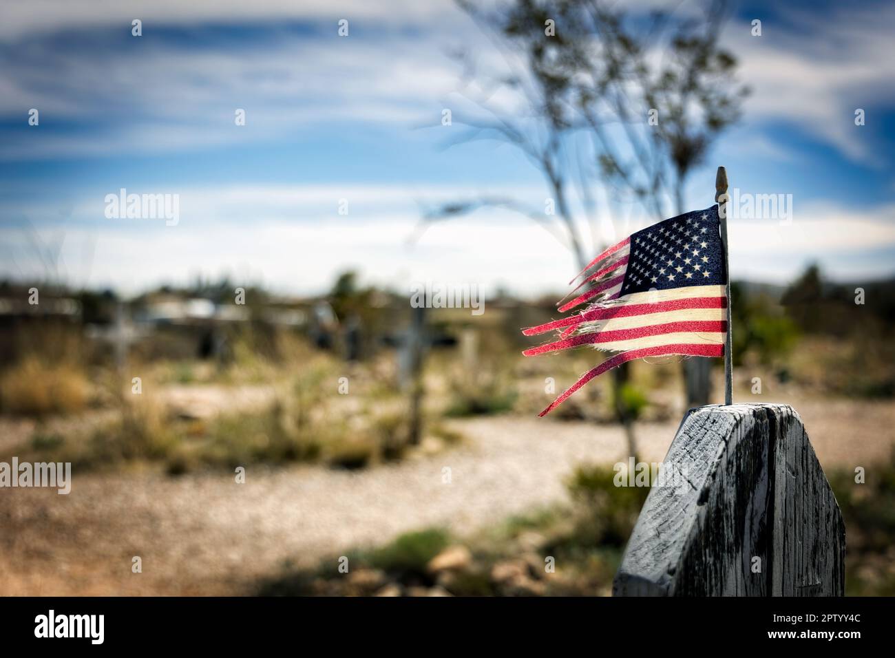 A tattered American flag attached to a grave marker at Boothill in ...