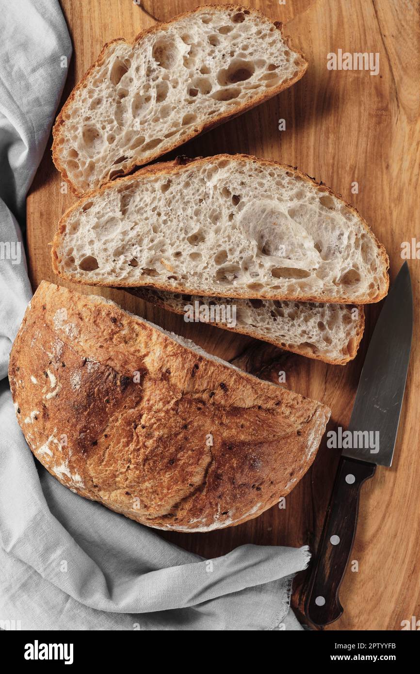 Sliced loaf of artisan sourdough bread on a cutting board. Top view ...