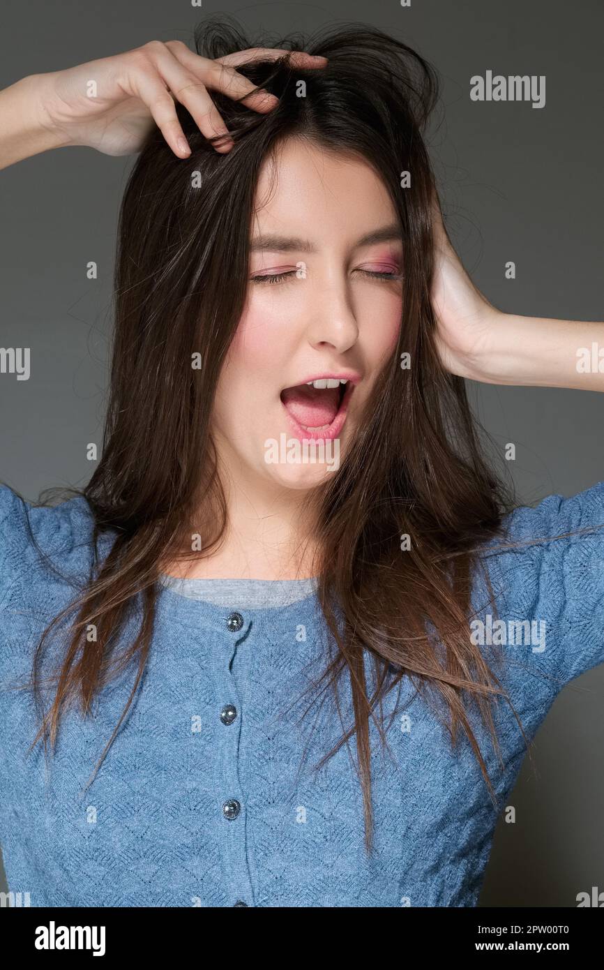 charming girl playing with her hair and making mess on head Stock Photo ...