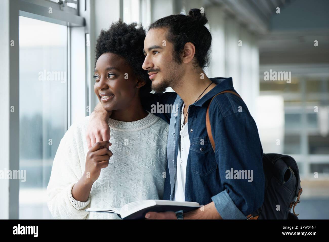 Thinking about their promising futures. A Couple in University holding ...