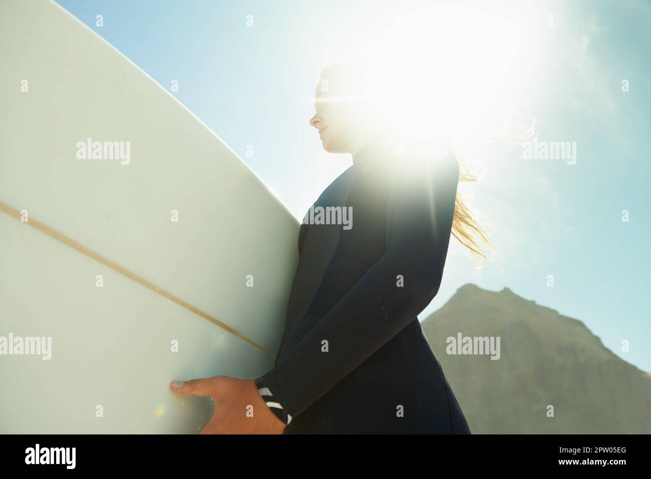 On Her Way Into The Ocean A Young Surfer Girl Holding Her Surfboard