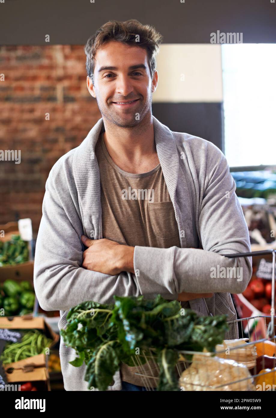 He always take the healthy choice. Portrait of a young man in a grocery ...