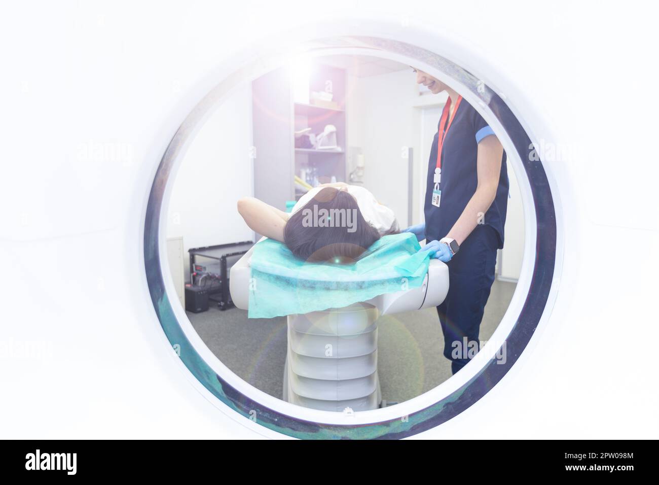 CT scan technologist overlooking patient in Computed Tomography scanner ...