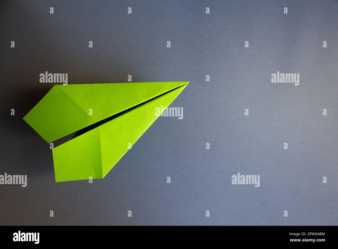 Green paper plane origami isolated on a blank grey background Stock ...