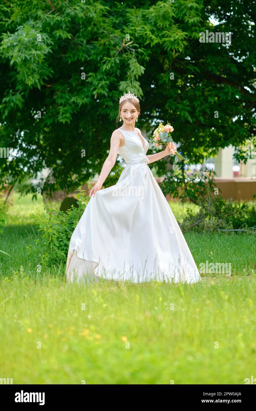 Portrait of pretty bride with coronet in hair outdoor near ceremony ...