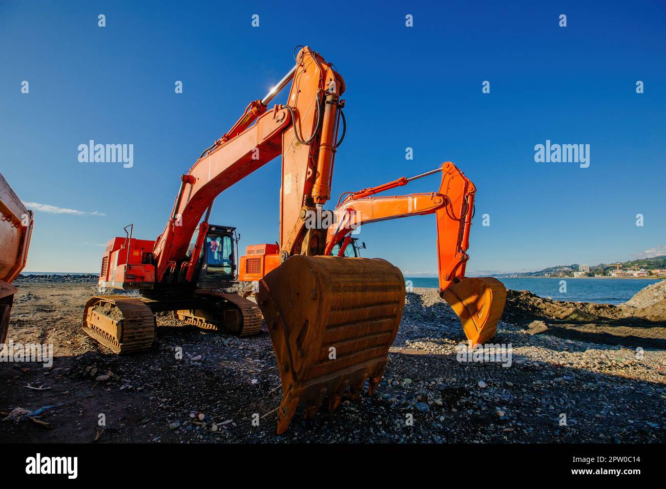 Excavators working on earthmoving at construction of new embankment ...