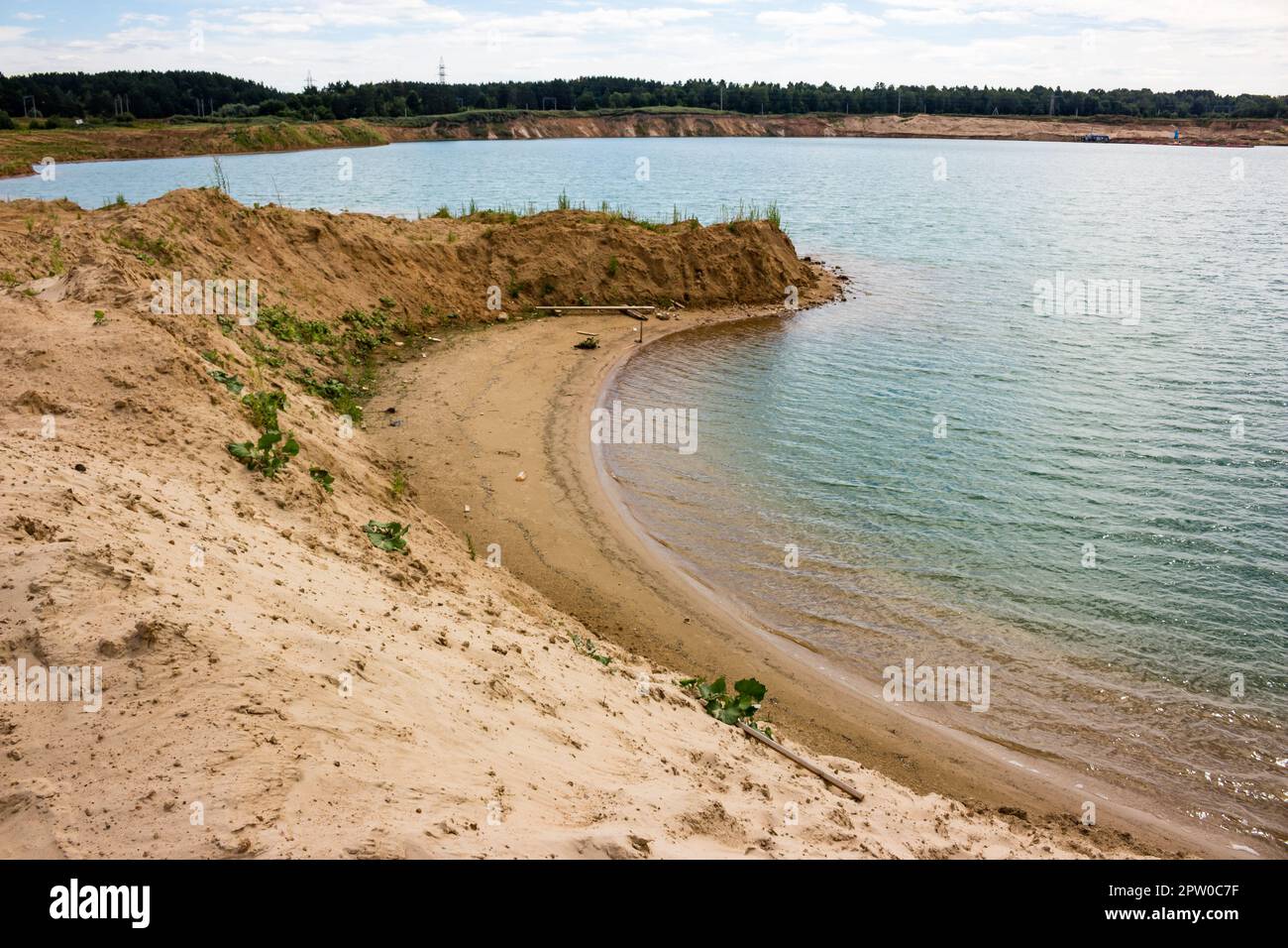Sandy shore on a flooded sand pit with bluish water Stock Photo - Alamy