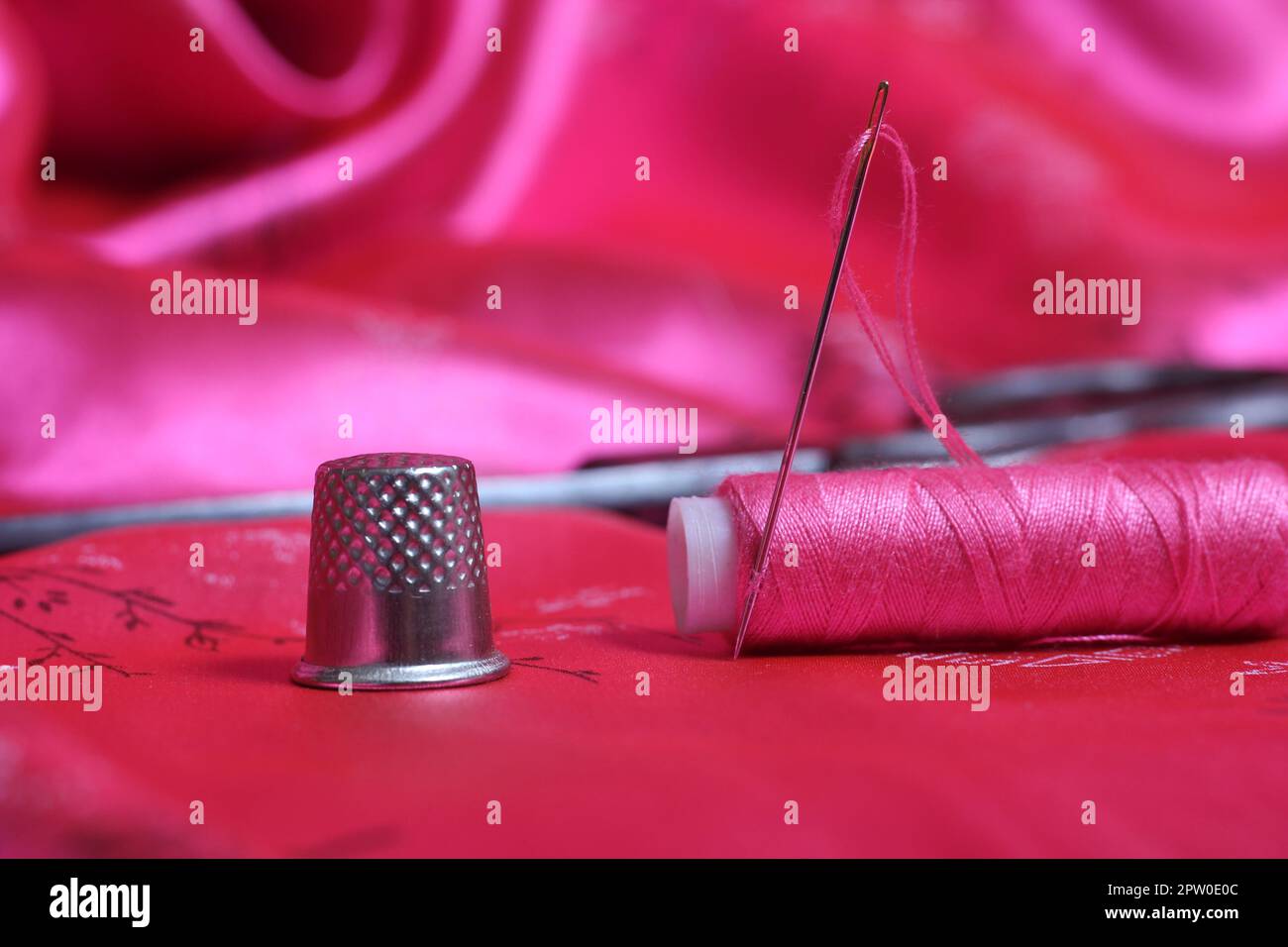 Spool of Pink Thread and Thimble on Vintage Pink Satin Stock Photo - Alamy