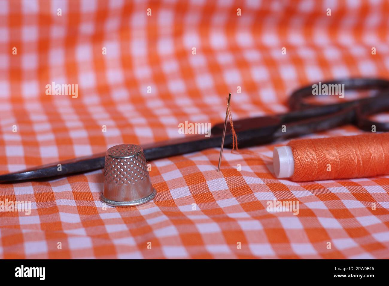 Orange and White Checkered Fabric With Thimble and Spool of Orange ...