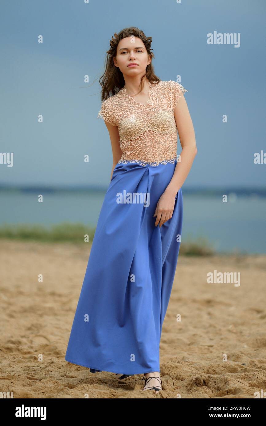 Gentle young woman walking on the sand in a cloudy day. Gentle woman in ...