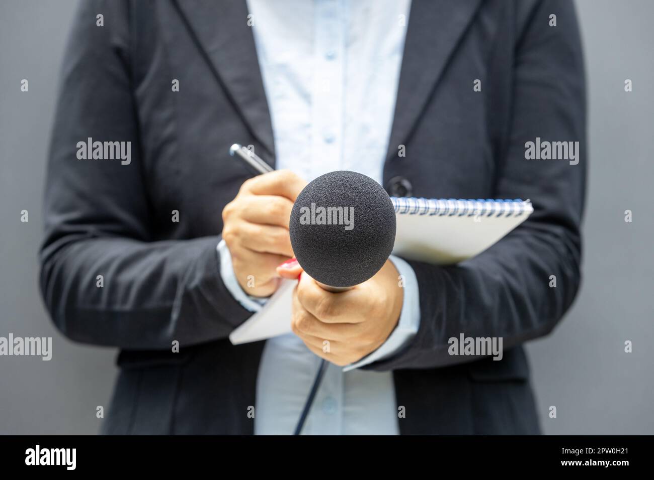 Female reporter at press conference or media event, writing notes ...