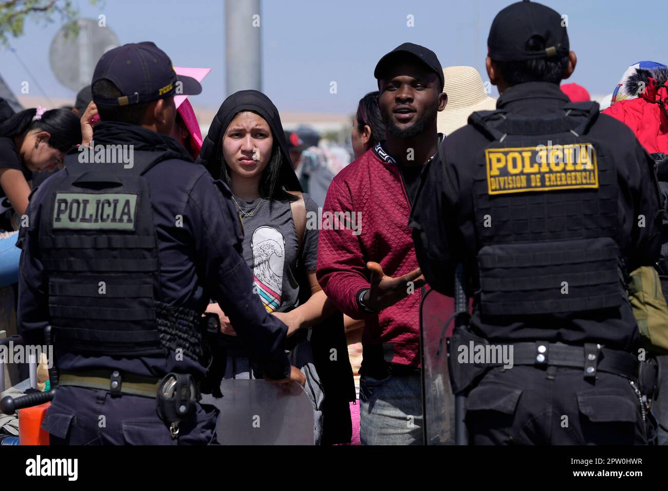 Venezuelan migrants speak with Peruvian police guarding the border with ...