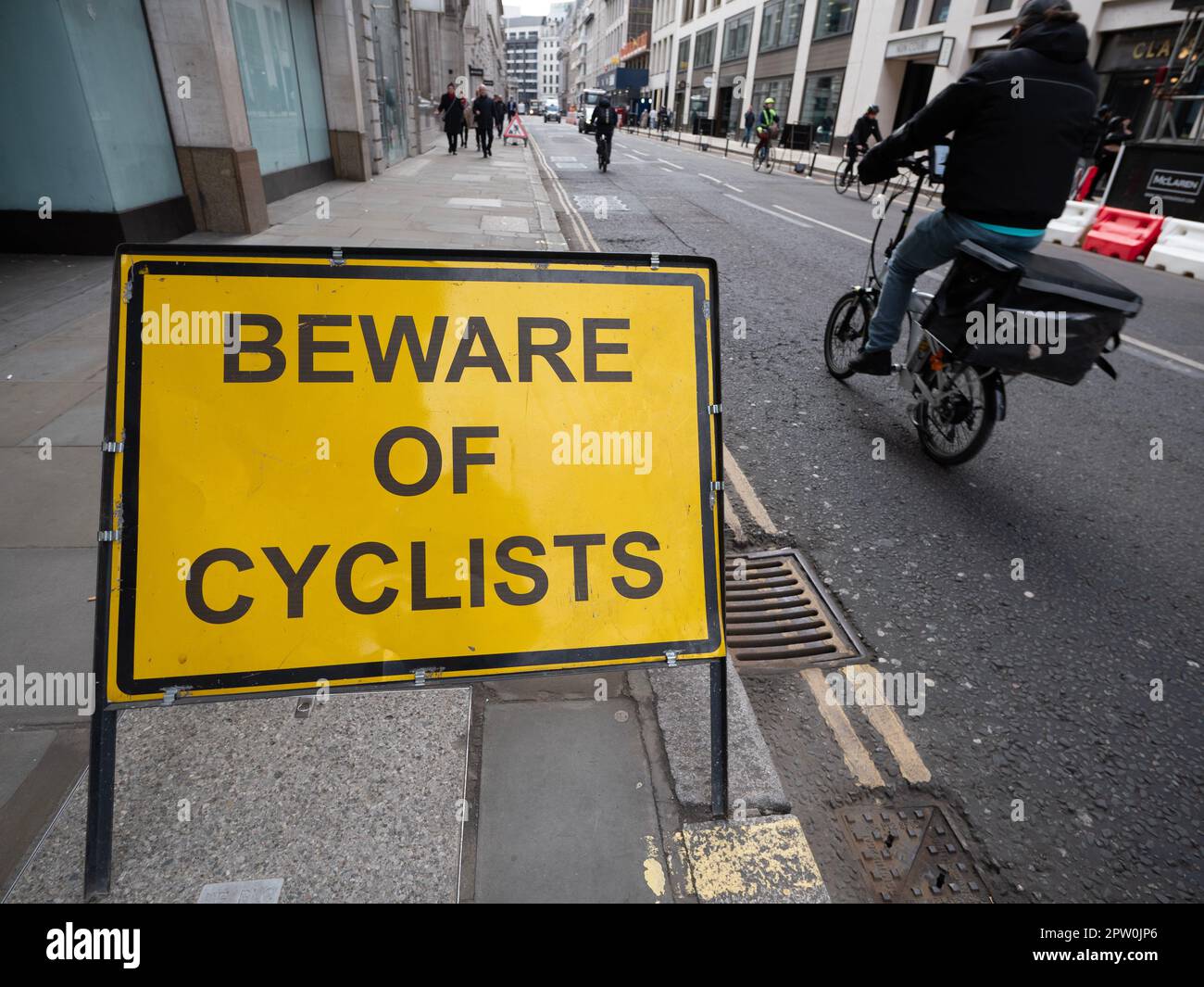 Beware of Cyclists sign in Central London with bicycle rider, riding ...