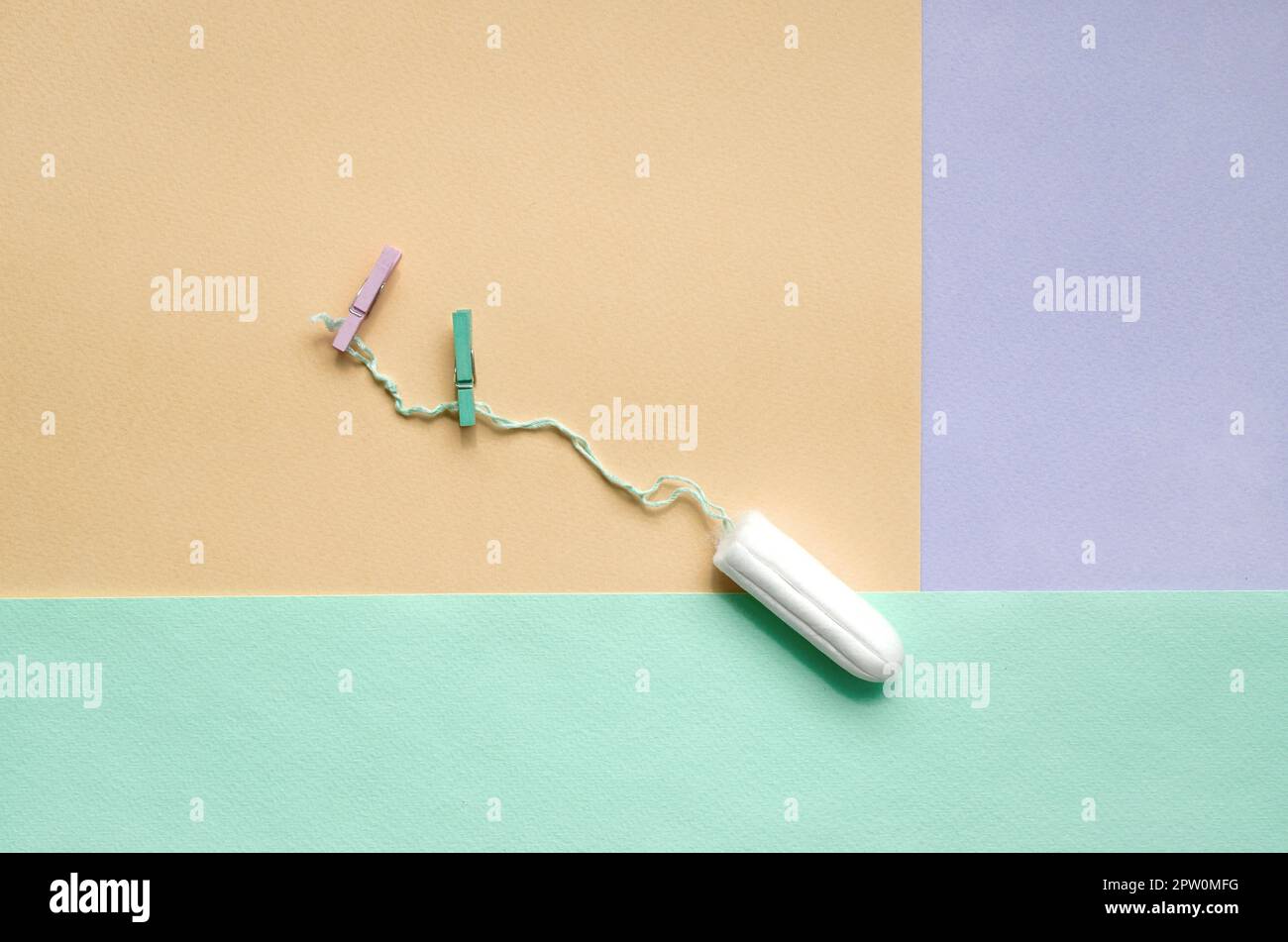 Tampon with two clothespins lie on texture background of fashion pastel ...
