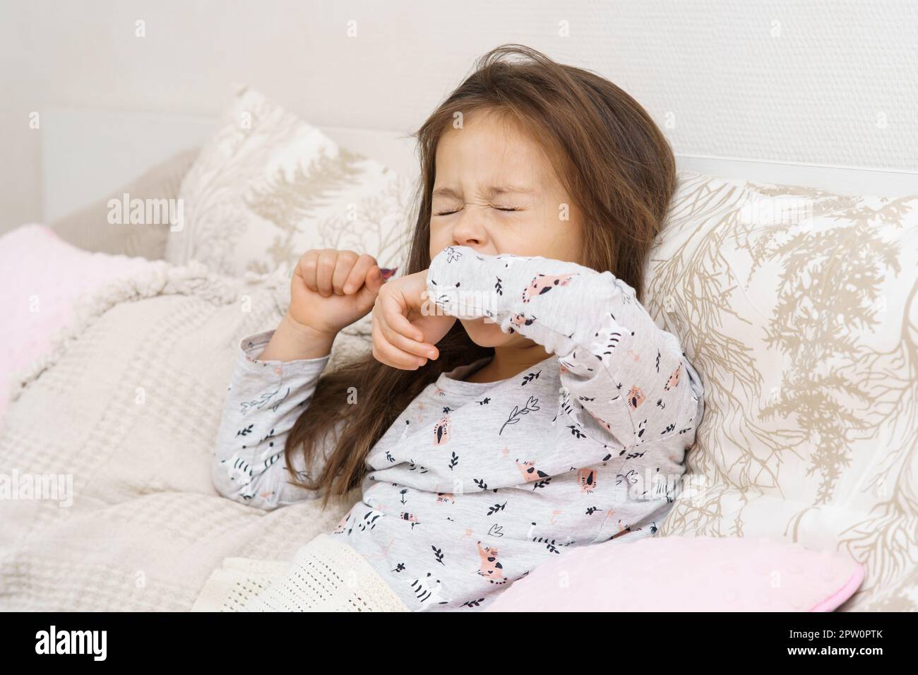 Exhausted little long haired brunette girl yawning or sneezing with ...
