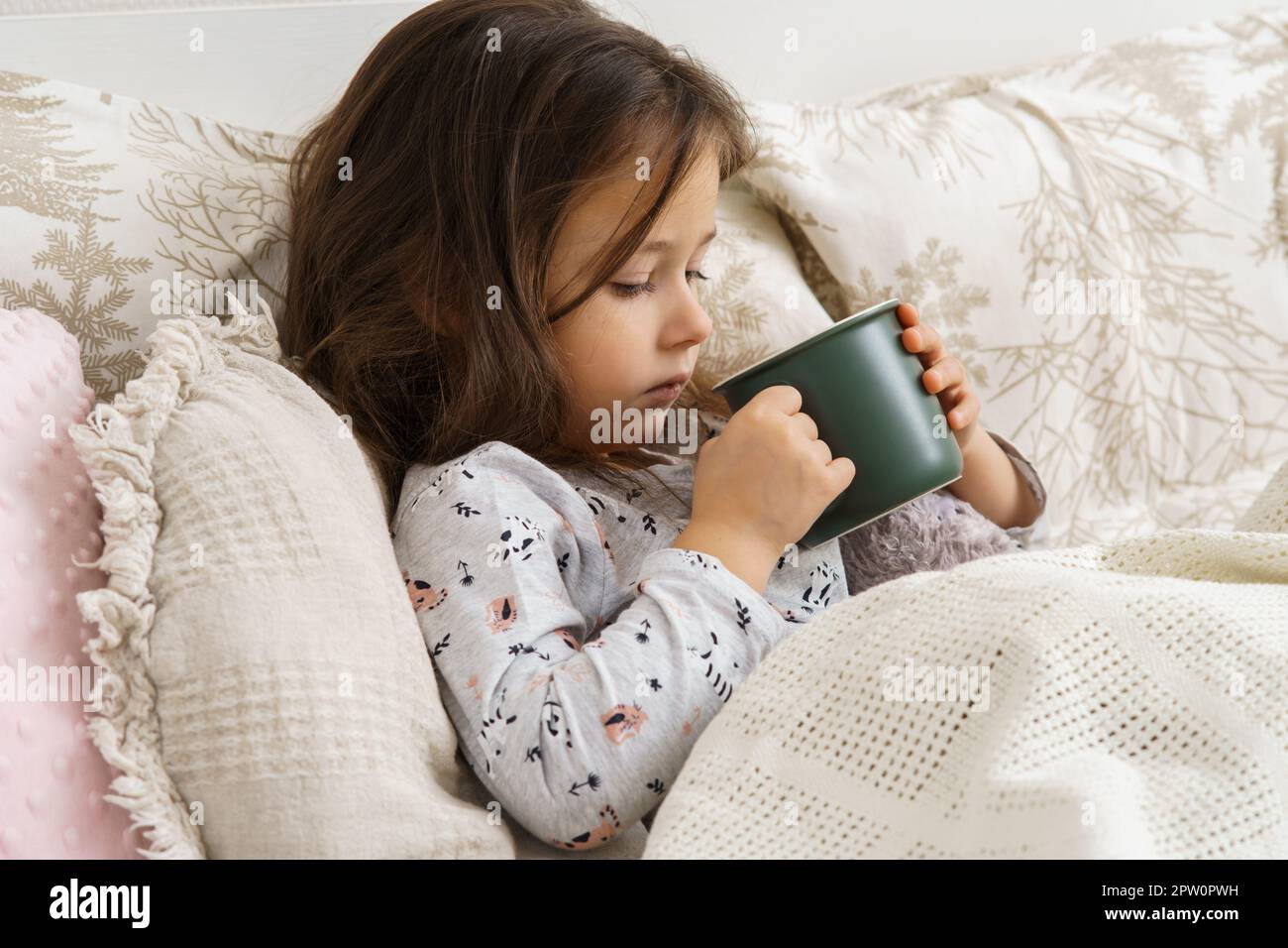 Sweet child, little dark haired preschooler girl drink hot unpalatable ...