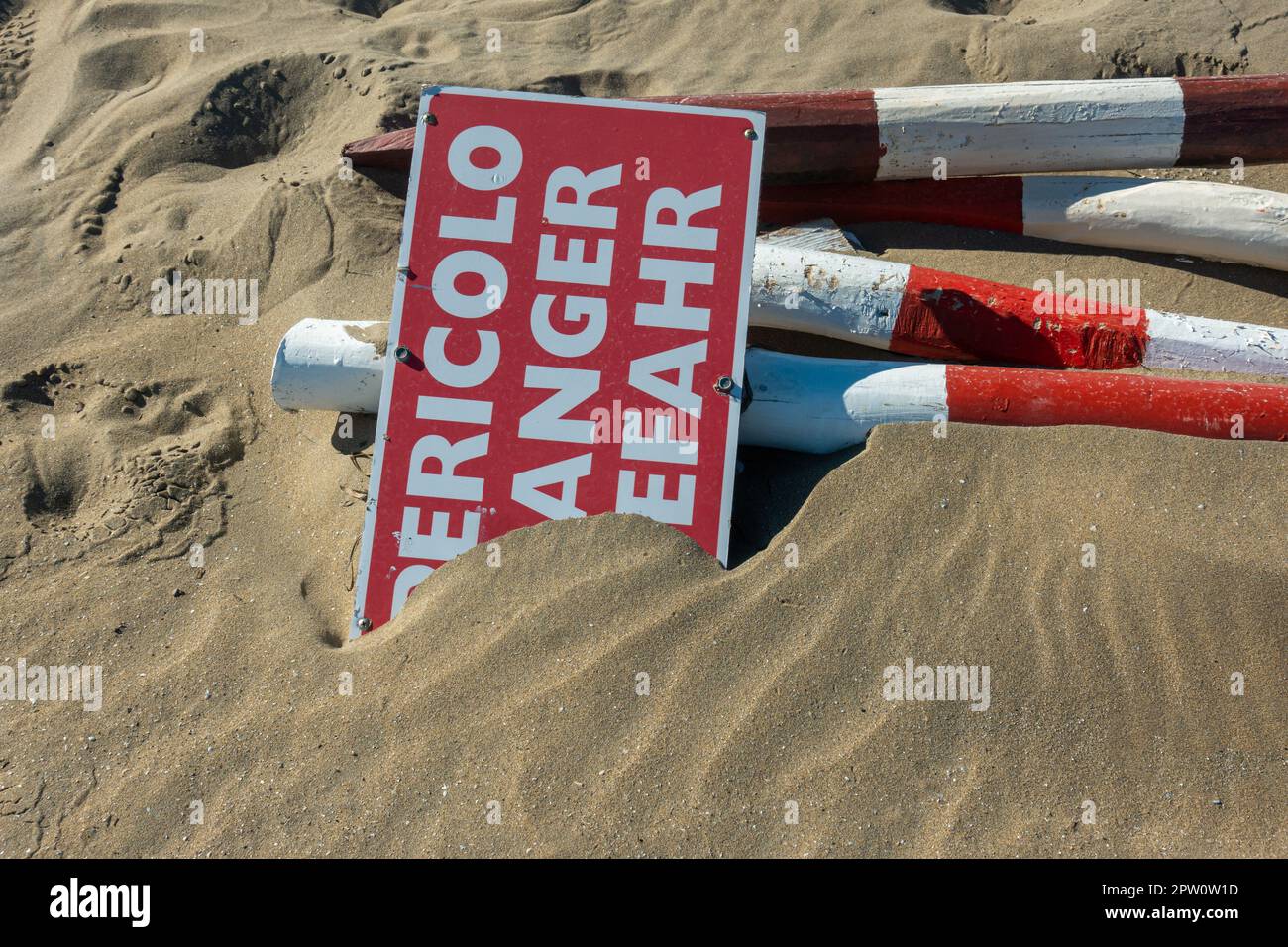 Fallen sign with "warning" in the sand Stock Photo - Alamy