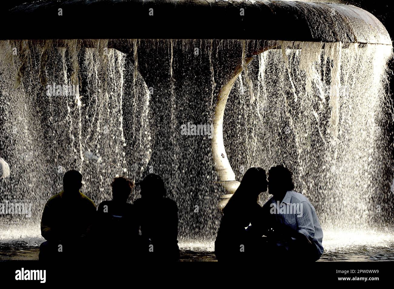 The silhouettes of people in front of the falling drops of water and ...