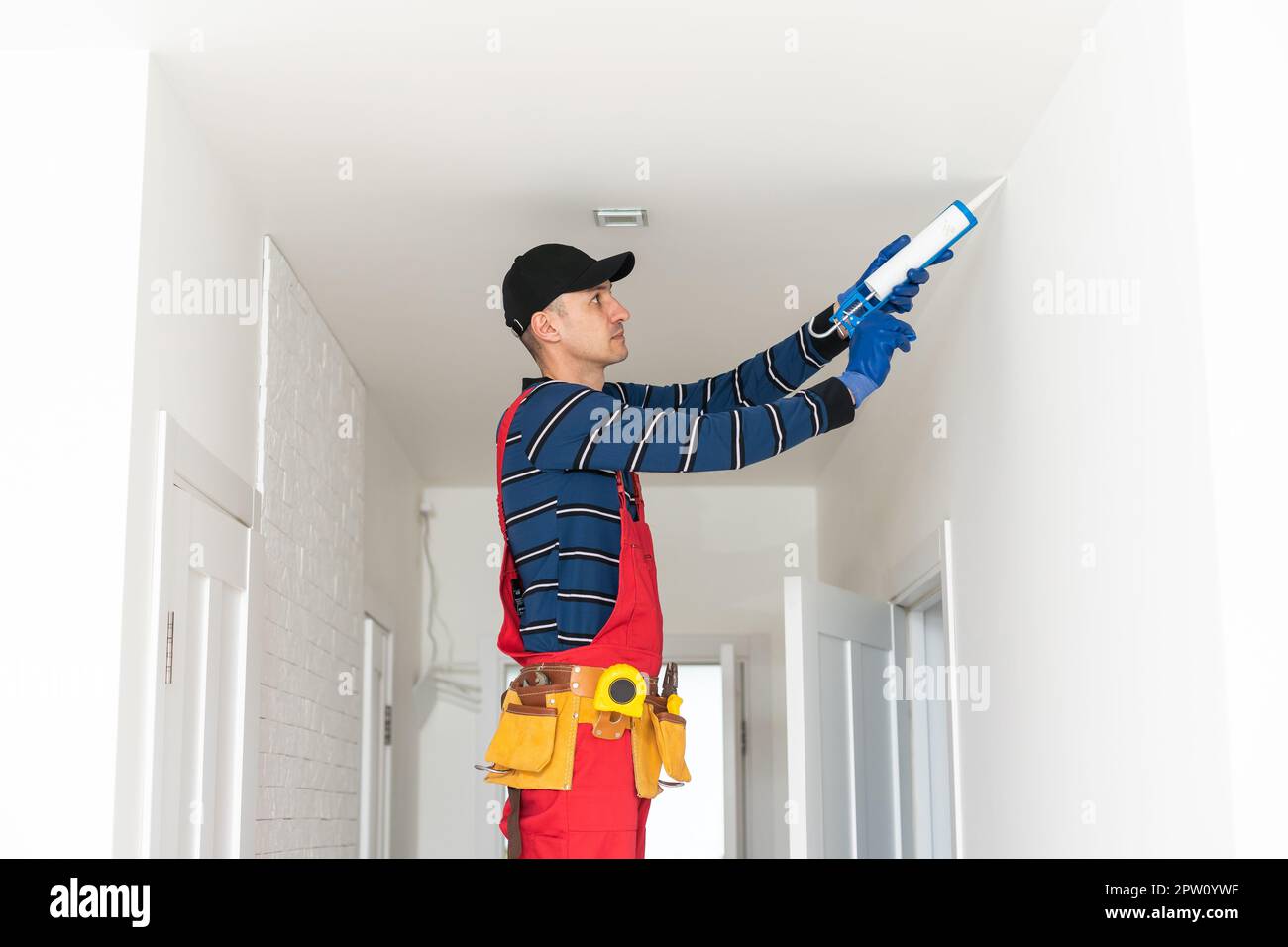 man plasterer construction worker at work, takes plaster from bucket ...