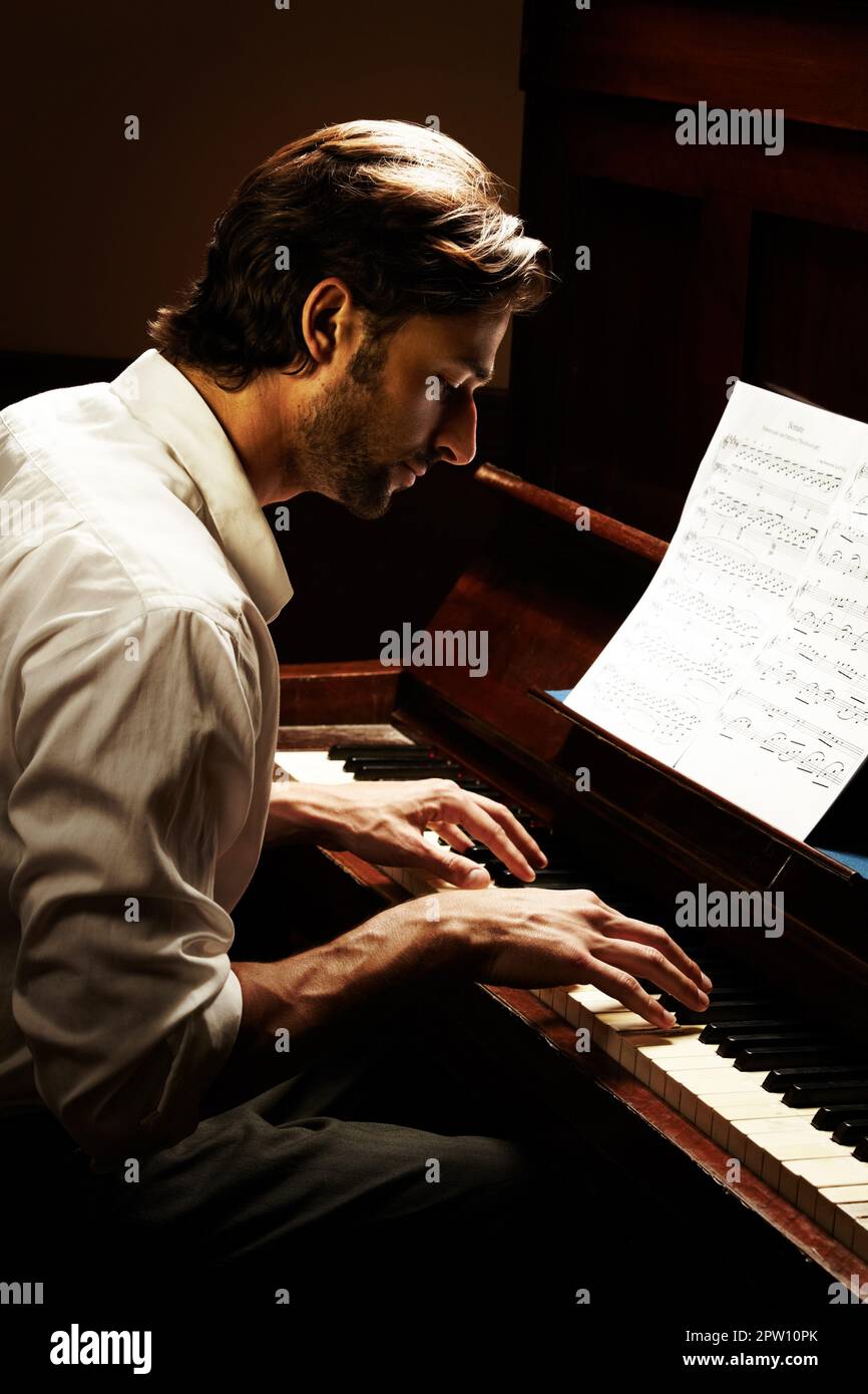 Making beautiful music. Profile of a handsome man playing the piano ...