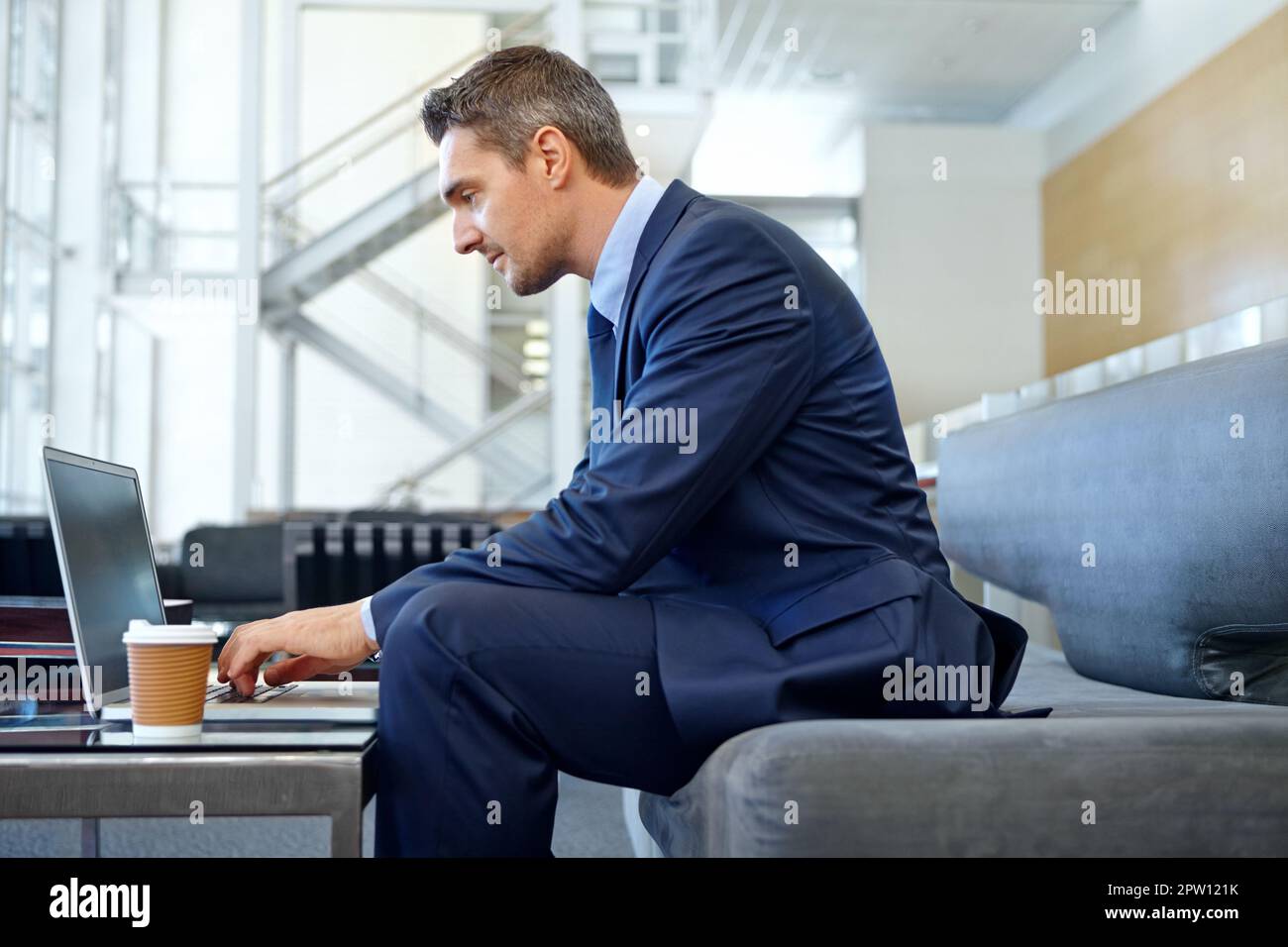 Checking his emails. Suit-clad mature businessman sitting in a ...