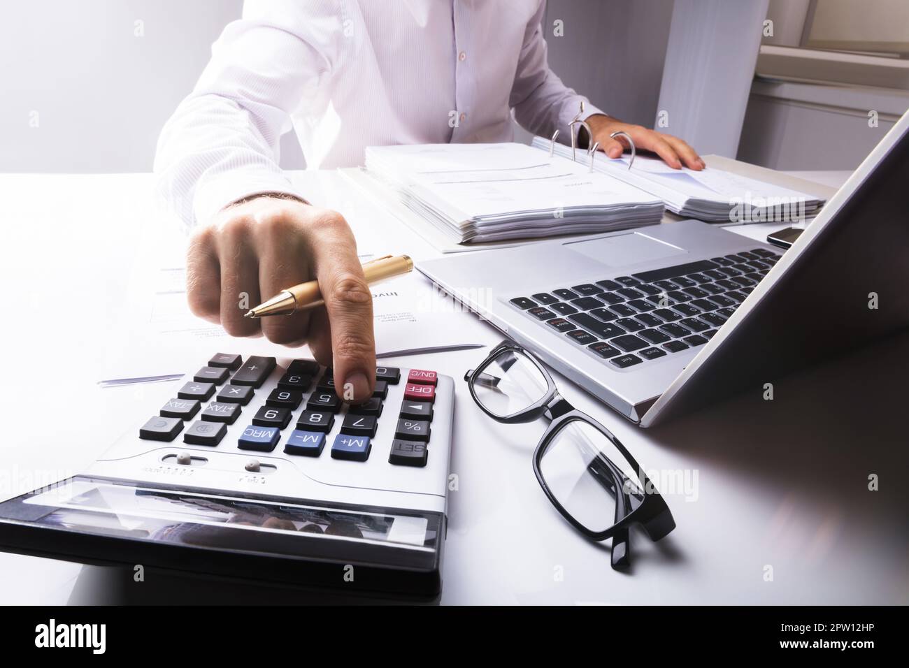 Tax Accountant Calculating Invoice In Office Using Laptop Stock Photo ...