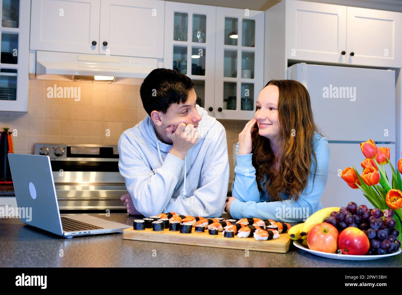 teenagers in kitchen looking after girl looking with loving eyes on ...