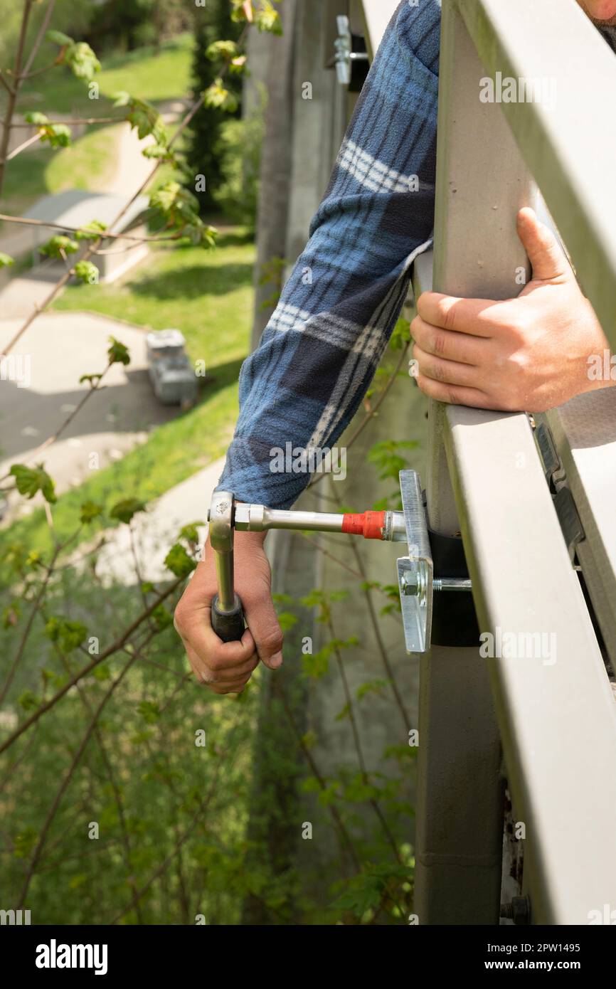 A workman installs a cable duct on a bridge railing high on a viaduct ...