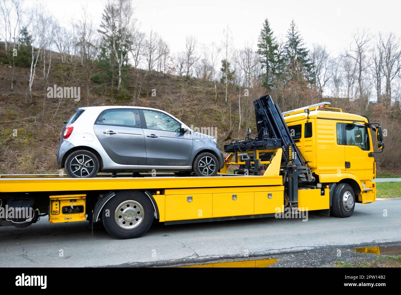A small electric car is loaded by the breakdown service. It has stopped ...