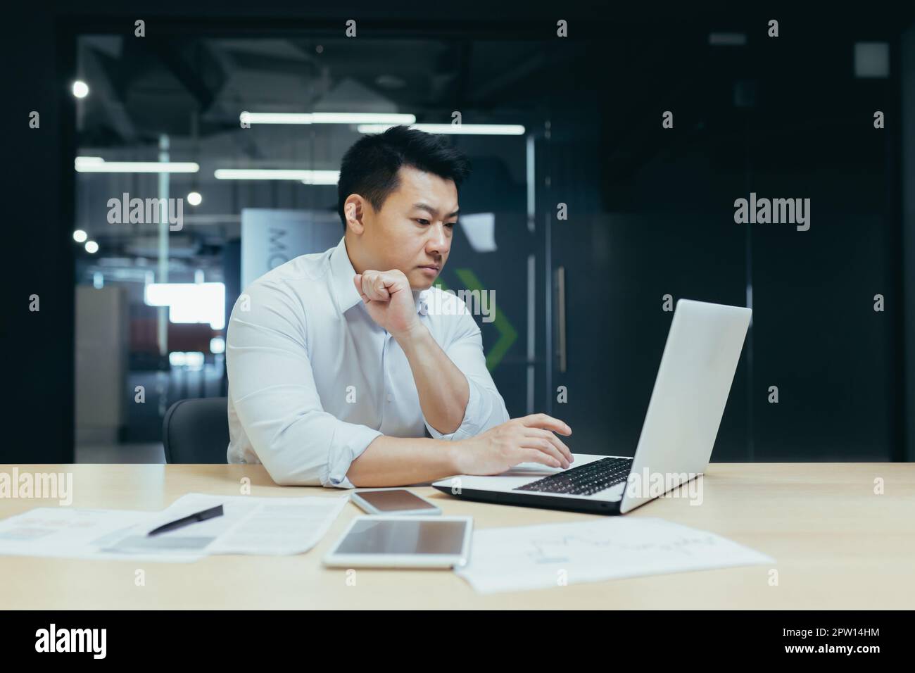 Serious and thoughtful young man of Asian origin programmer, developer ...