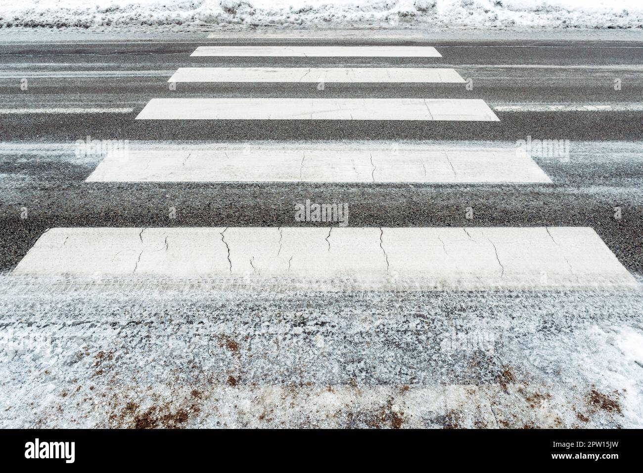 Snow, ice, and winter mud at a pedestrian crossing. The air temperature ...