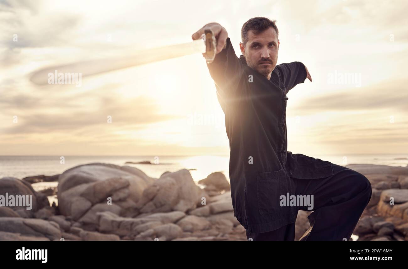 Man, sword and zen thai chi balance on beach for fitness training ...